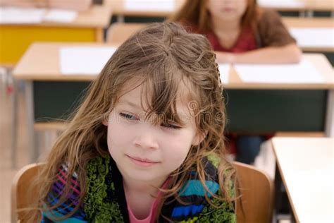 Beautiful Teenage Girl Sitting In College Or High School Class Stock