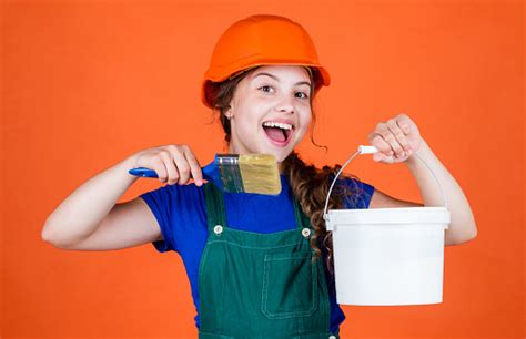 이것은 완벽 할 것입니다 그림 브러시와 양동이를 들고있는 안전 헬멧에있는 행복한 소녀 페인트 할 준비가되었습니다 보호 헬멧 페인팅 벽에있는 소녀 어린 시절 발달 아이 빌더