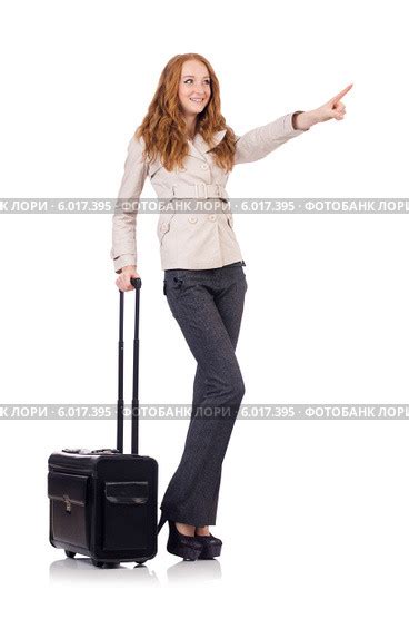 Молодая симпатичная путешественница с чемоданом показывает на что то указательным пальцем