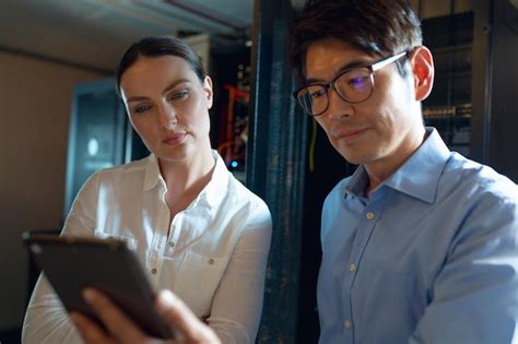 Premium Photo Diverse Male And Female Engineers Using Digital Tablet In Computer Server Room