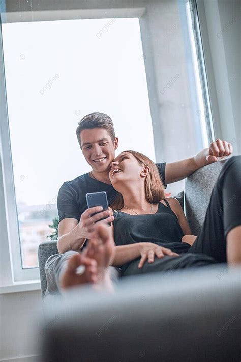 Affectionate Couple Scrolling Through Pictures On Their Mobile Device Photo Background And