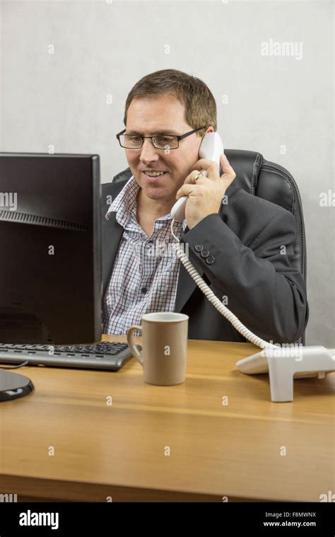 A Man Working At His Computer In The Office Stock Photo Alamy