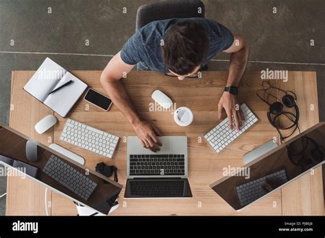 Overhead View Of Programmer Using Computers At Workplace Stock Photo