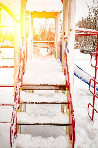 화창한 겨울 날에 눈 속에서 밝은 놀이터 눈으로 뒤덮인 겨울 놀이터에서 어린이 스윙스윙 겨울 눈이 내린 후 어린이 엔터테인먼트를 위한 다채로운 놀이 세트 0명에 대한 스톡