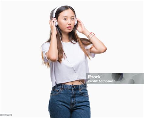 젊은 아시아 여성 착용 헤드폰 고립 된 배경과 스마트 얼굴 심각한 생각에 자신감을 표현 하는 음악을 듣고 감정에 대한 스톡 사진 및 기타 이미지 Istock