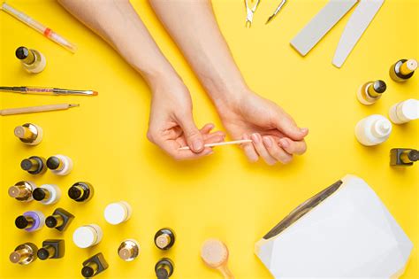 매니큐어네일 케어 미용 개념 케어에 대 한 모든 젤 광택 제를 만들기 위한 도구입니다 노란색 배경에 여자는 손톱의 매니큐어를 가져옵니다 가위에 대한 스톡 사진 및 기타