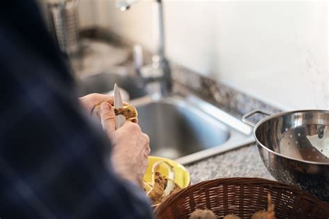 격리 요리 남자가 그들을 요리하기 전에 일부 감자를 껍질을 벗기고있다 Sable Color에 대한 스톡 사진 및 기타 이미지 Sable Color 가정 생활