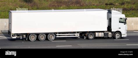 Side View White Clean Supply Chain Unmarked Hgv Lorry Truck And Articulated Trailer Driving