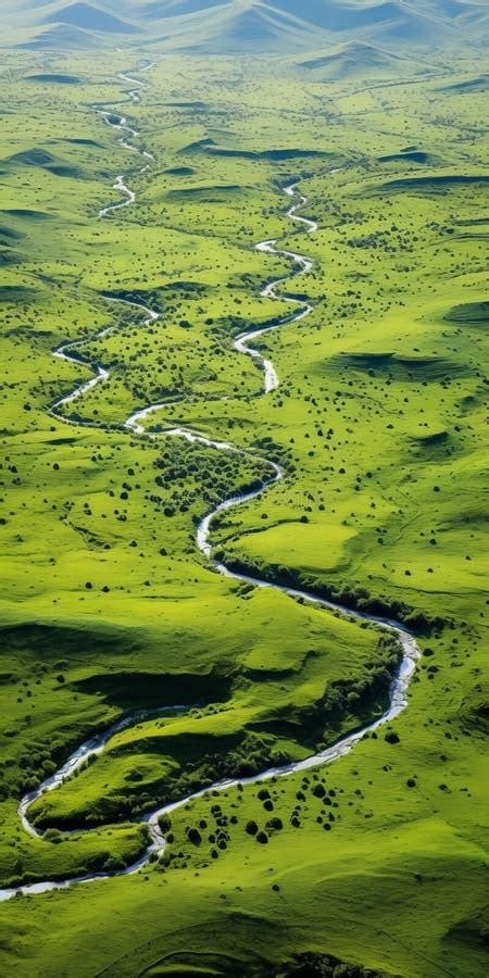 Tranquil Aerial View Of River Winding Through Green Grassland Stock