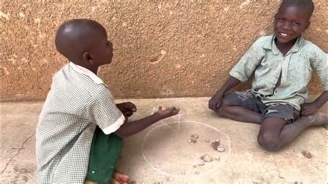 우간다 초등학교 점심시간 교실 벽에서 놀고 있는 아이들 우간다식 공기놀이인가 하는 방식을 보니 공기놀이랑 비슷해 보이는데 돌을 던지고 받으며 밀어 놓은 돌을 원 밖으로