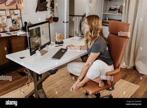 Woman Using Computer On Desk At Home Stock Photo Alamy
