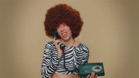 Crazy Girl With Brown Lush Wig Talking On Wired Vintage Telephone Of