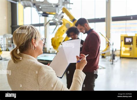 Team Of Engineers Engaged In Discussion About Robotics And Automation
