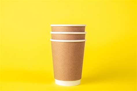 노란색 배경에 분리된 종이 일회용 컵 3개 무료 사진