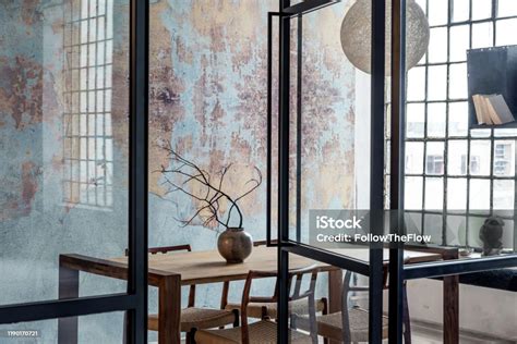 나무 공유 테이블 의자 꽃병과 우아한 액세서리로 로프트 아파트의 식당의 세련된 인테리어 디자인 현대적인 홈 장식 밝고 햇볕이 잘 드는 산업 공간 템플릿 0명에 대한 스톡