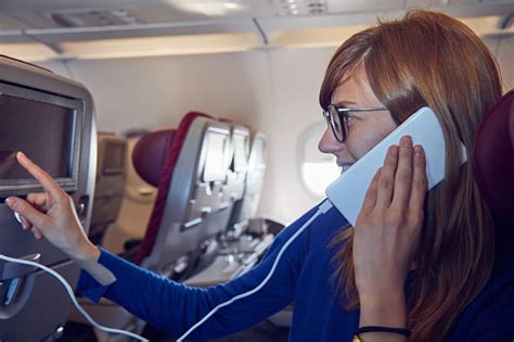 현대 비행기 좌석에서 휴대 전화를 사용 하는 여자입니다 Usb 케이블에 대한 스톡 사진 및 기타 이미지 Usb 케이블 관광 관광객 Istock