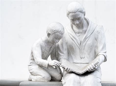 Two Statues Sitting Side By Side On A Bench With One Of The Figures