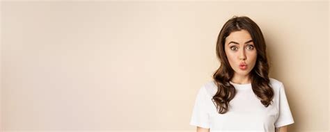 Feche O Retrato De Uma Menina Morena Surpresa E Excitada Parecendo Espantada Reagindo