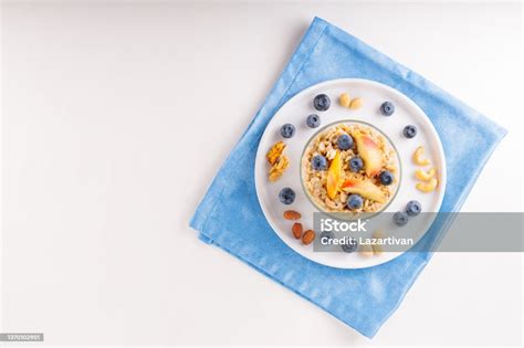 오트밀 블루베리 사과 다양한 견과류를 곁들인 건강한 조식 오트밀 죽 그릇에 딸기와 사과 조각이 흰색 접시에 새어 있습니다 다이어트 음식 개념 위쪽 보기 0명에 대한 스톡