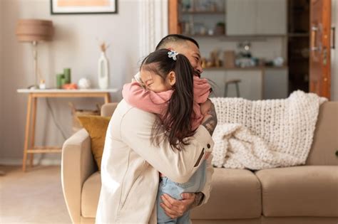 Little Japanese Daughter Embracing Her Daddy Expressing Love At Home