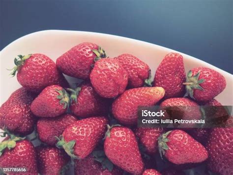접시에 딸기 회색 배경 화이트 요리와 맛있는 붉은 큰 정원 딸기 건강한 음식 비타민 채식주의 식단 음식과 함께 살고 있습니다