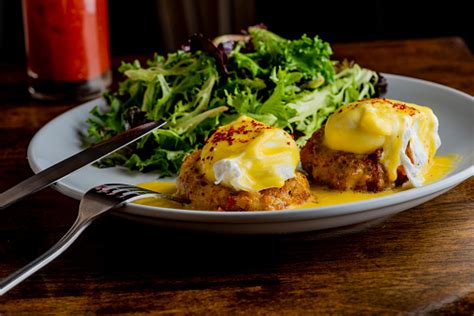 계란 베네딕트 신선한 아보카도와 토마토를 곁들인 전통적인 클래식 미국 식당 또는 프렌치 비스트로 브런치 메뉴 수제 홀란다이즈 소스를 데친 달걀 위에 얹고 아보카도를 영국식