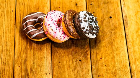 나무 테이블에 화려한 도넛 유약 뿌리와 달콤한 착빙 설탕 식품 초콜릿 프로스팅도넛 복사 공간이 있는 상단 보기 개념에 대한 스톡