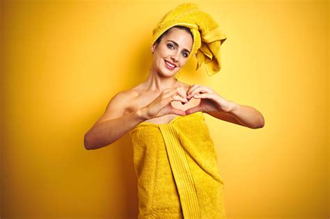 아름 다운 여자 몸에 샤워 수건을 입고 노란색 고립 된 배경 에 머리 미소 사랑 하 고 심장 기호 모양으로 손으로 로맨틱 한 개념 수건에 대한 스톡 사진 및 기타 이미지