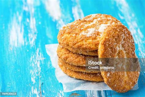 파란 나무 부엌 테이블에 양피지 종이에 갓 구운 오트밀과 코코넛 쿠키의 스택 호주 안작 비스킷 레시피 미니멀한 스타일의 복사 공간 Anzac Day에 대한 스톡 사진 및