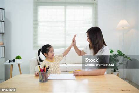 귀여운 아이와 엄마의 손이 화려한 물감으로 그림을 그리는 동안 5 개를줍니다 아시아 소녀와 어머니는 크레용 드로잉 컬러를