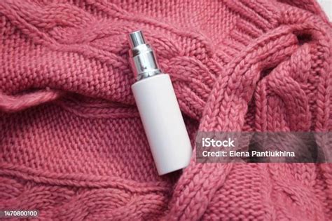 로션이 든 흰색 병 부드럽고 따뜻한 밝은 분홍색 스카프 스웨터의 배경에 모이스처 라이저 모캡 겨울 피부 관리 화장품 0명에 대한