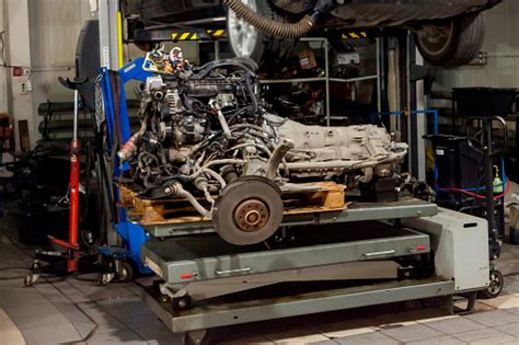 스포츠 자동차 리프트 수리를 위해 그리고 그것의 밑에 분리 된 엔진을 바퀴 양쪽에 누워 파란 크레인과 차량 수리가 게에서 리프팅