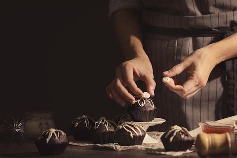 Premium Photo Woman Decorating Tasty Cupcake At Table