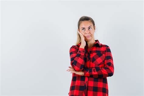 뺨에 손을 잡고 잠겨있는 전면보기를 찾고 캐주얼 셔츠에 젊은 아가씨 무료 사진