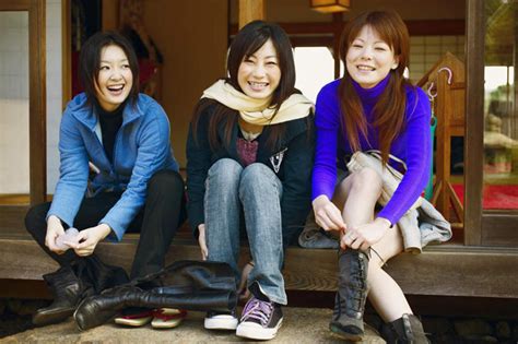 东方人三个人伙伴朋友坐笑微笑露齿笑横图室外白天正面友谊门亚洲一排拉门服装整齐装饰注视休闲装黄种人