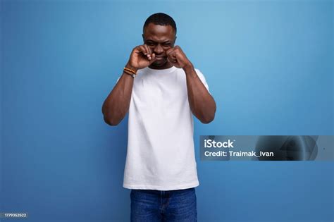 흰색 티셔츠를 입은 젊은 아프리카 남자가 스튜디오 배경에 복사 공간이 있는 화가 났다 25 29세에 대한 스톡 사진 및 기타 이미지 25 29세 30 39세 귀여운