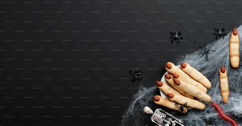 할로윈 구성 마녀 손 손가락 거미줄 거미 검은 배경에 해골 플랫 레이 평면도 할로윈 과자 개념입니다 사진 Unsplash의 손가락 이미지