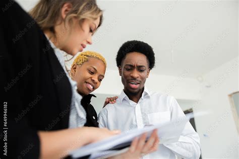 Blonde Real Estate Agent Leads The Way With A Warm Smile As The African