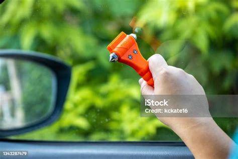 여자는 자동차에 안전 망치와 안전 벨트 커터를 사용 비상 사태 때 유리를 깰 자동차 안전 빨간 망치에 비상 사태의 경우 잔디