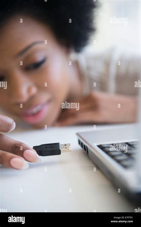 African American Woman Plugging Usb Cable Into Laptop Stock Photo Alamy