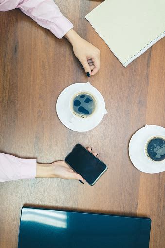 비즈니스 협상 후 커피 휴식 사무실에서 일하는 동안 커피 휴식 테이블에 손으로 커피 한 잔 상단보기 커피 한 잔을 들고 있는 여성의 손 경영자에 대한 스톡 사진 및 기타