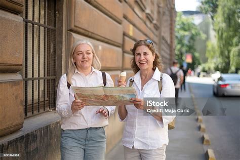 Mature Female Travelers Examining Map During Their Summer Travel Stock