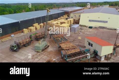Automated Log Sorting At A Sawmill Aerial View Crane Unloads Logs To
