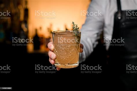 흐린 배경에 바텐더의 손에 로즈마리로 장식 된 칵테일이있는 유리의 아름다운 전망 Gin Tonic에 대한 스톡 사진 및 기타