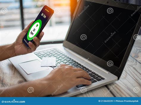 Человек держит смартфон для того чтобы смотреть на монитор функции
