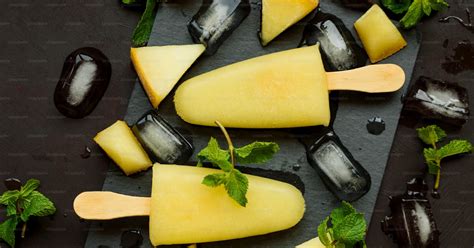 수제 멜론 아이스크림 팝 또는 아이스 캔디와 얼음 멜론 슬라이스 및 민트를 직사각형의 어두운 슬레이트 플레이트에 넣습니다 여름 음식 플랫 레이 상위 뷰 사진