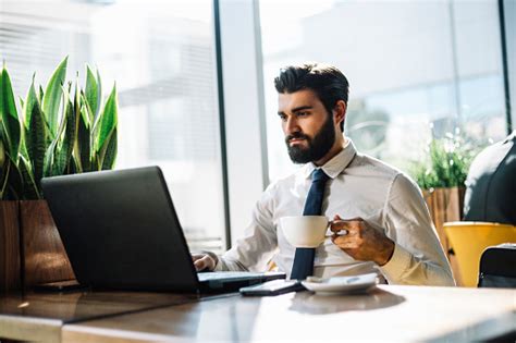 매력적인 젊은 사업가 음료 커피와 사무실에서 노트북을 사용 하 여 개념에 대한 스톡 사진 및 기타 이미지 개념 개발 검색