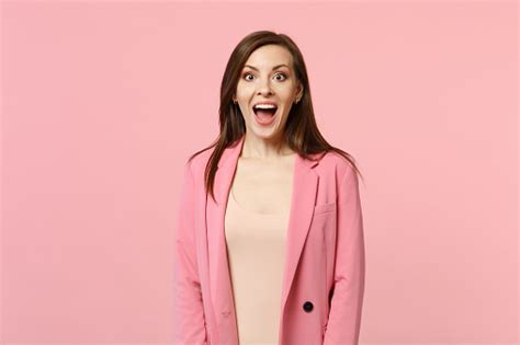 깜짝 젊은 여자의 초상화는 재킷을 입고 카메라 스튜디오에서 파스텔 핑크 배경에 고립 된 입 넓은 오픈을 유지 사람들은 진심으로 감정 라이프 스타일 개념입니다 복사 공간을