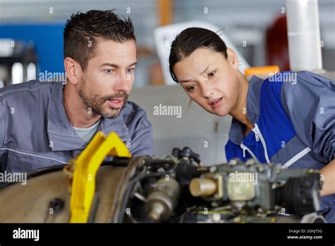 Confused Male And Female Mechanic Examining Car Engine Stock Photo Alamy