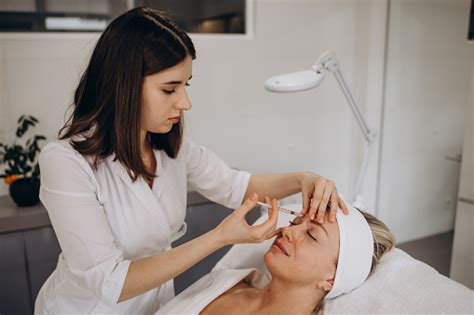 미용사는 아름다운 여성의 얼굴에 젊어지게하는 주름 방지 주사를합니다 미용실의 여성 미용 디자인에 대한 스톡 사진 및 기타 이미지 디자인 보톨리눔 독소 주사 25 29